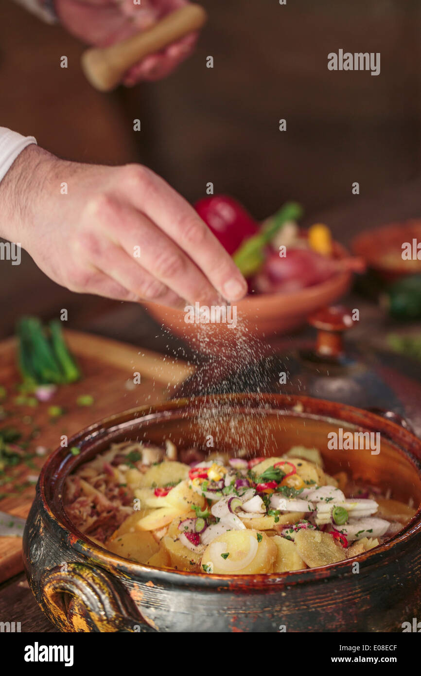 Unrecognizable person seasoning food Stock Photo - Alamy