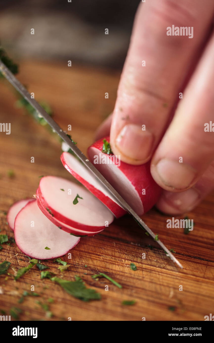 Person cutting radishes, close-up Stock Photo - Alamy