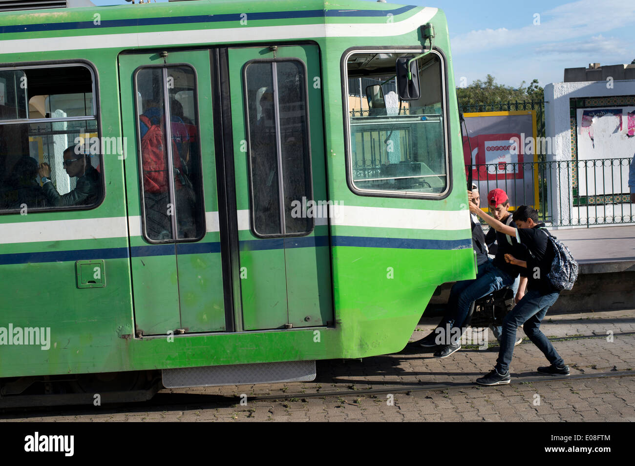 Tunis, Tunisia. The tram..known as the metro. Boys hitch a ride on the ...