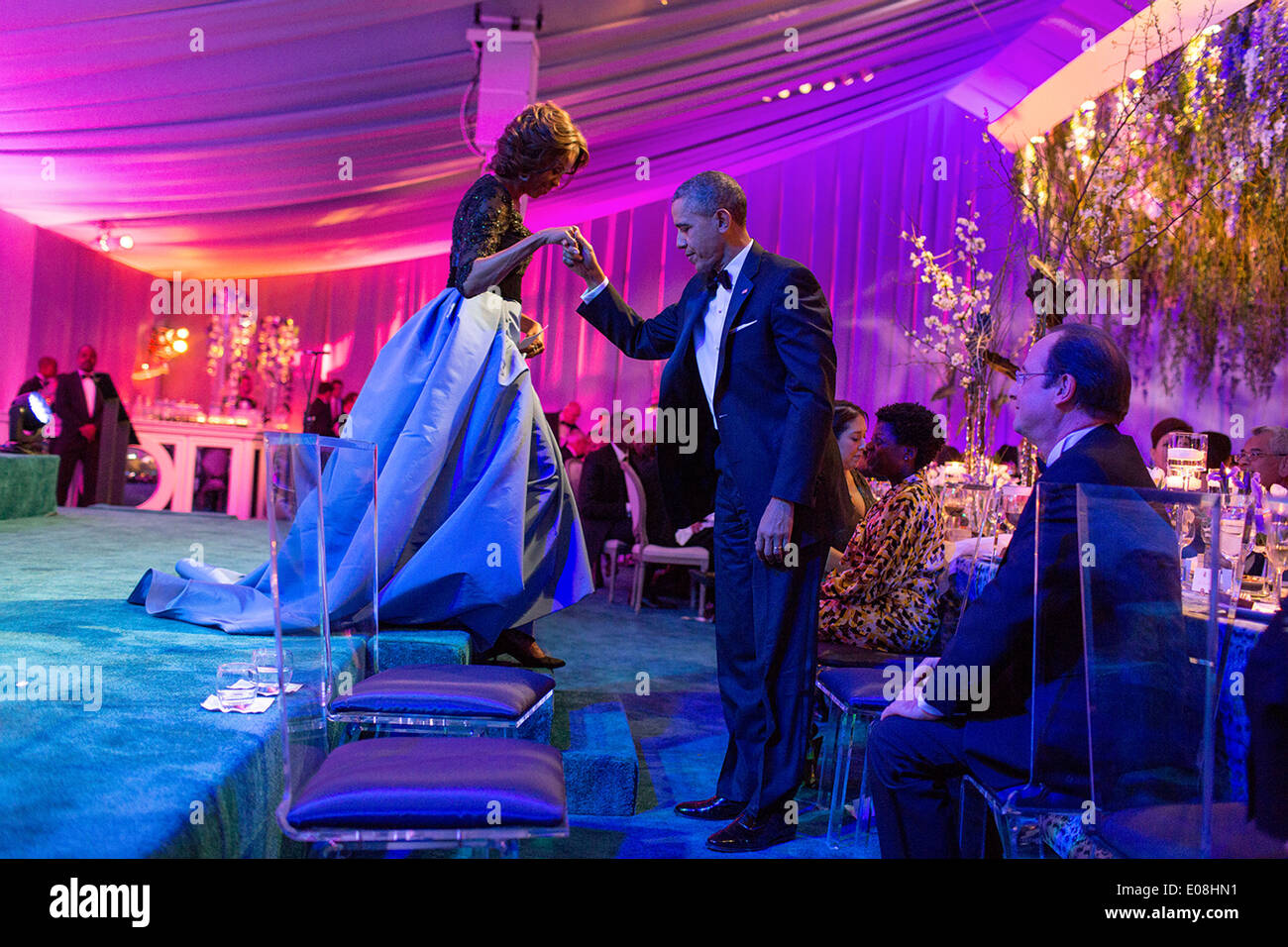 US President Barack Obama helps First Lady Michelle Obama off the stage ...