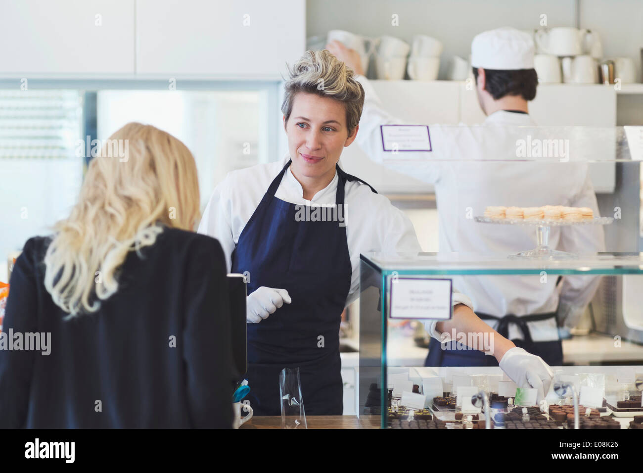 Female cafe worker attending customer at counter Stock Photo - Alamy