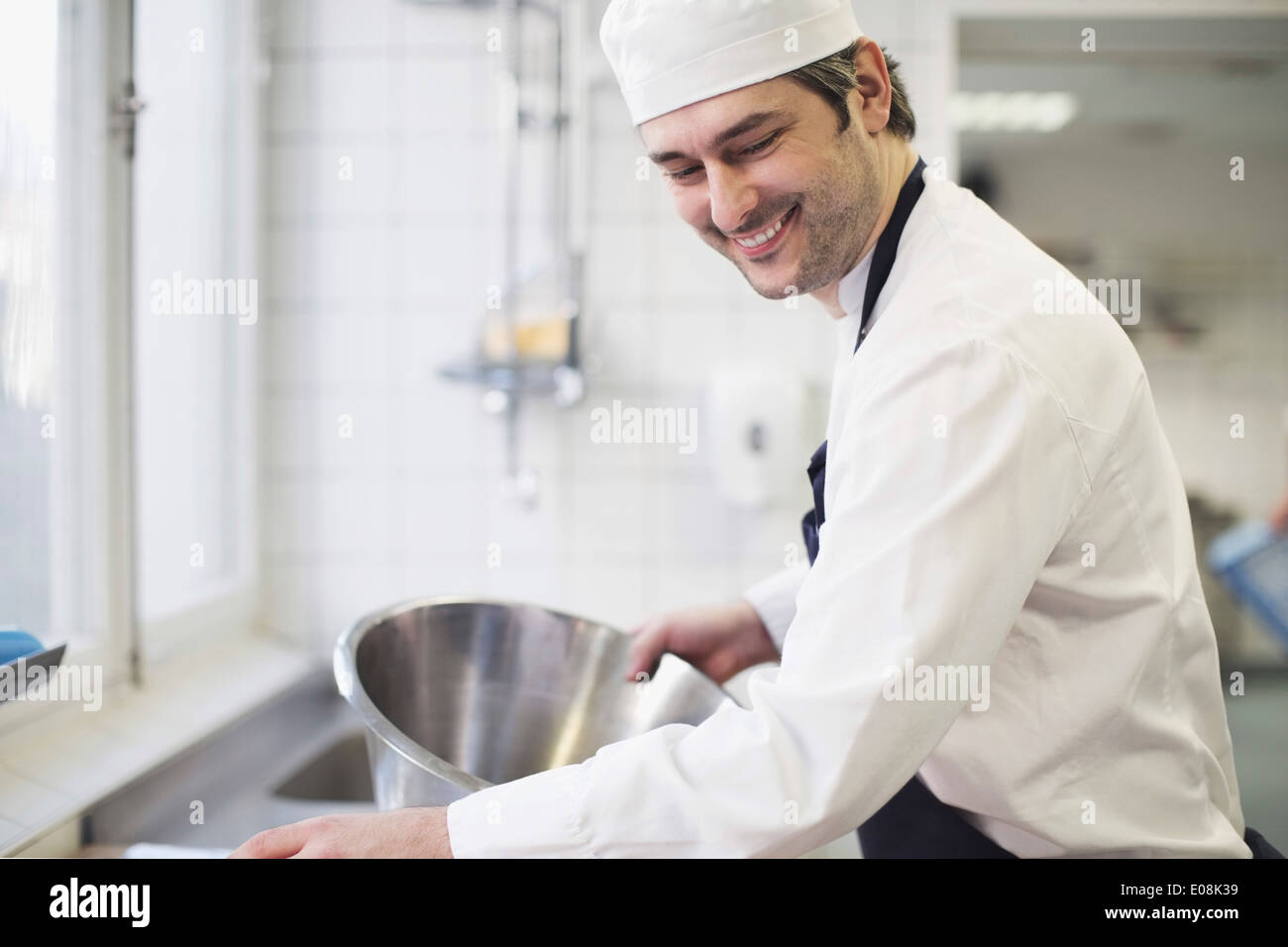 Happy baker working in commercial kitchen Stock Photo - Alamy