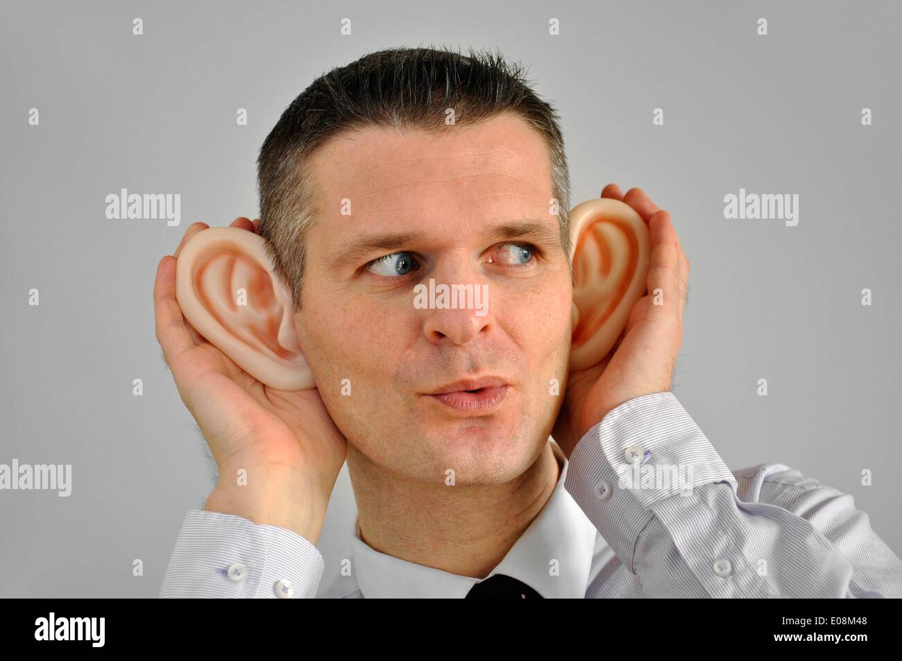 Illustration - A man wearing giant rubber ears spies on the surrounding ...