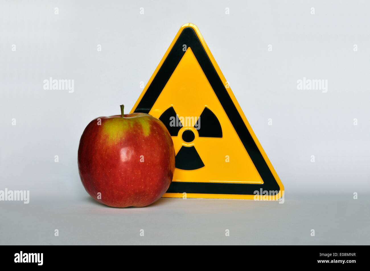 Illustration - An apple stands in front of a radioactive trefoil sign ...