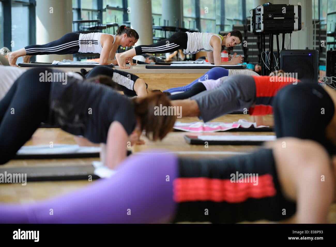 Fitness instructor doing plank exercises during a class at the gym ...