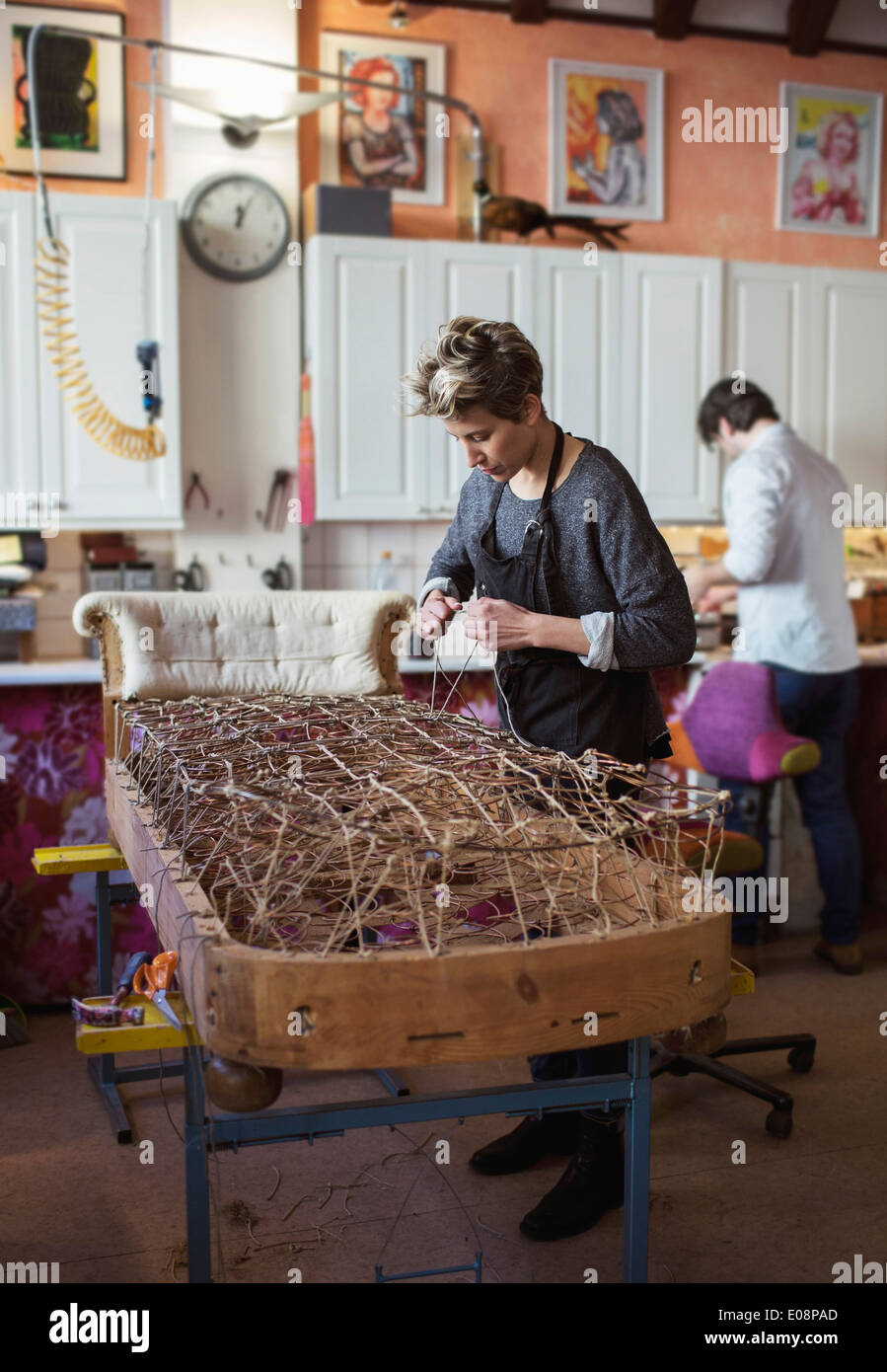 Female worker fixing rope on chaise longue at workshop Stock Photo - Alamy