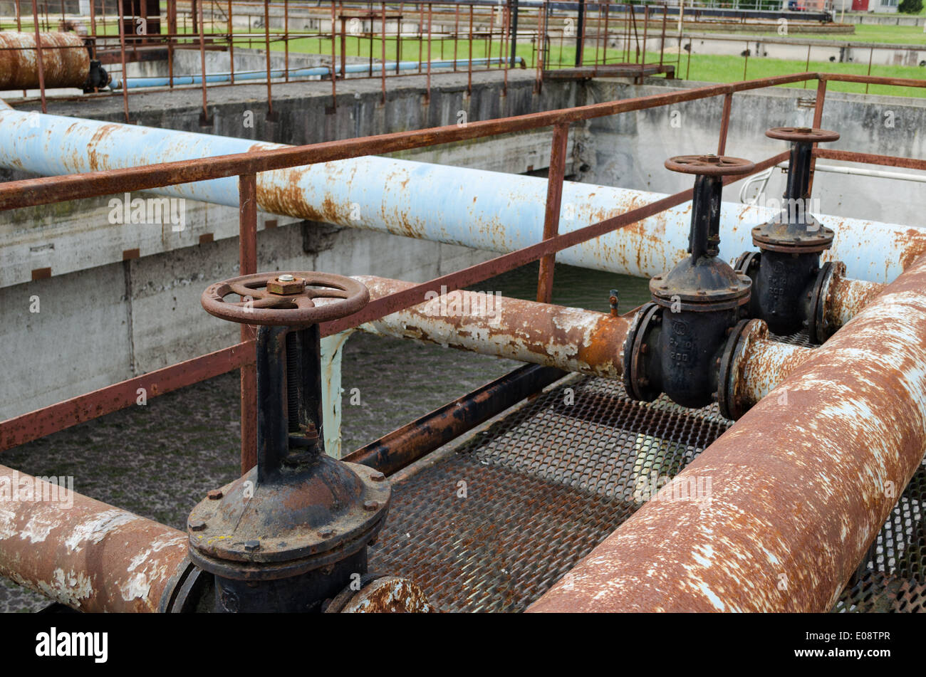Rusty big tap valve gate and pipes in water treatment plant and dirty ...