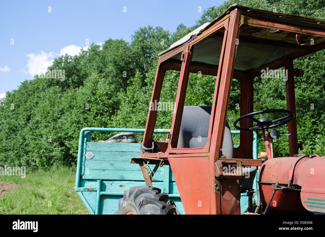 old rustic work tractor in green field outdoor Stock Photo - Alamy