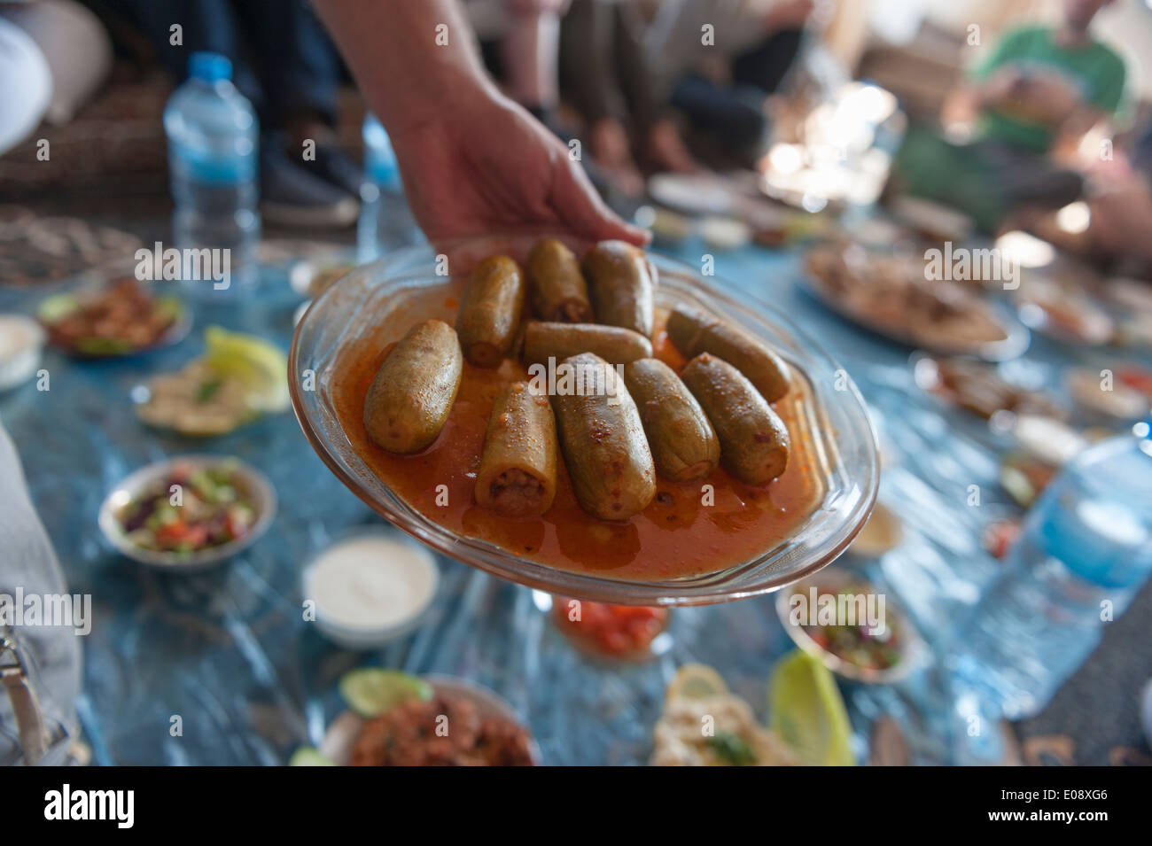 A group of tourists having a traditional lunch with a local family in ...
