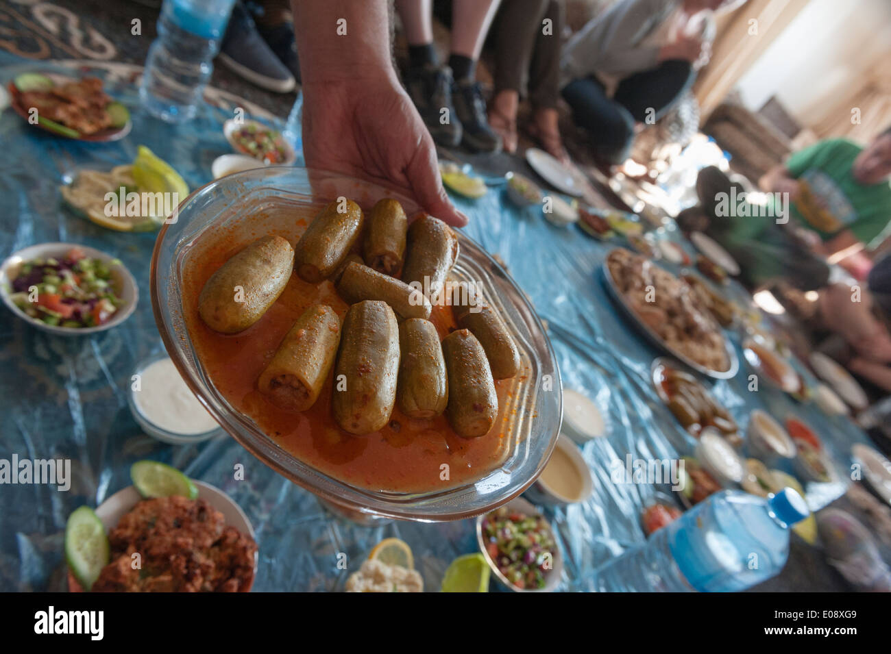A group of tourists having a traditional lunch with a local family in ...