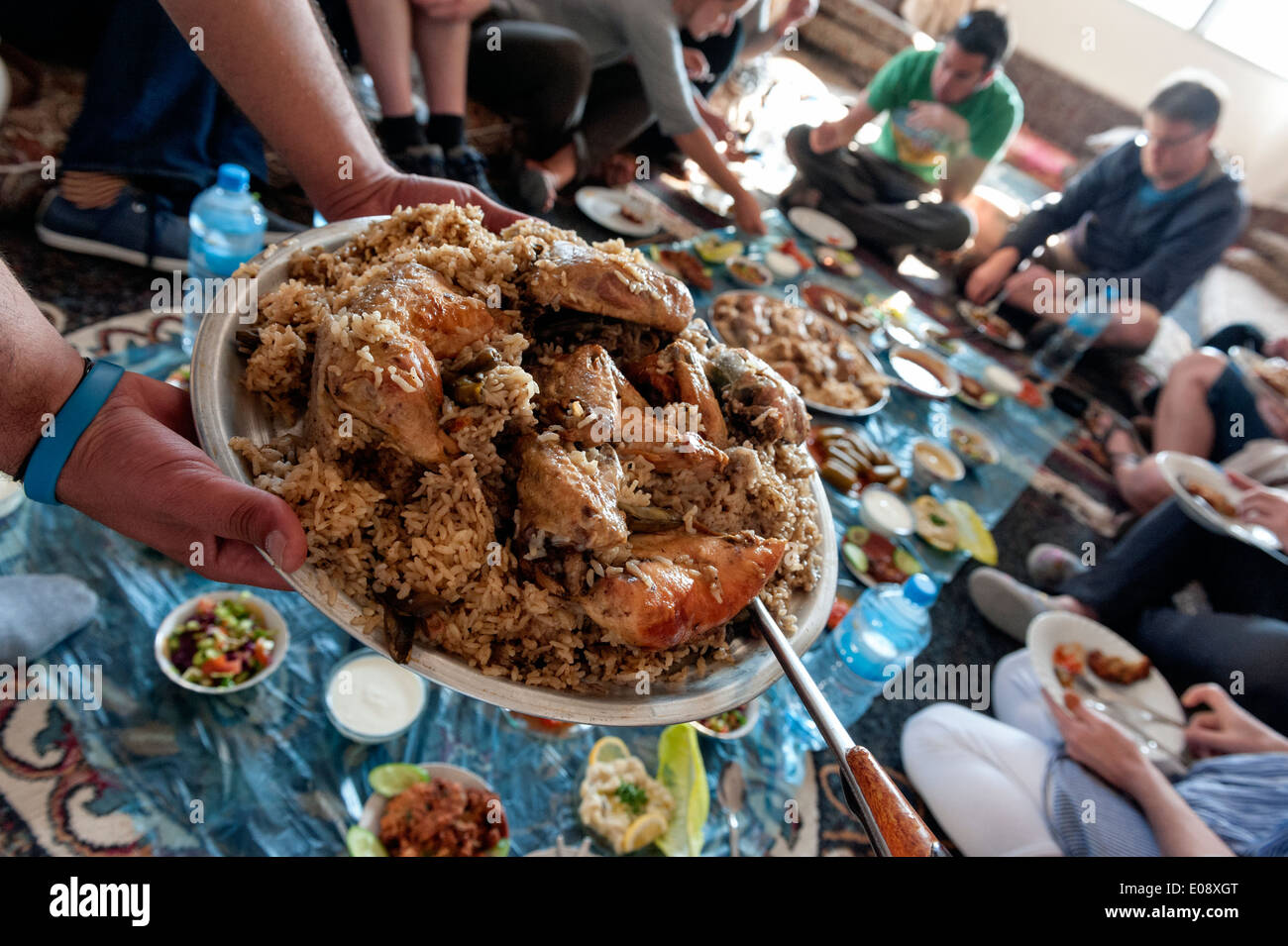 A group of tourists having a traditional lunch with a local family in ...