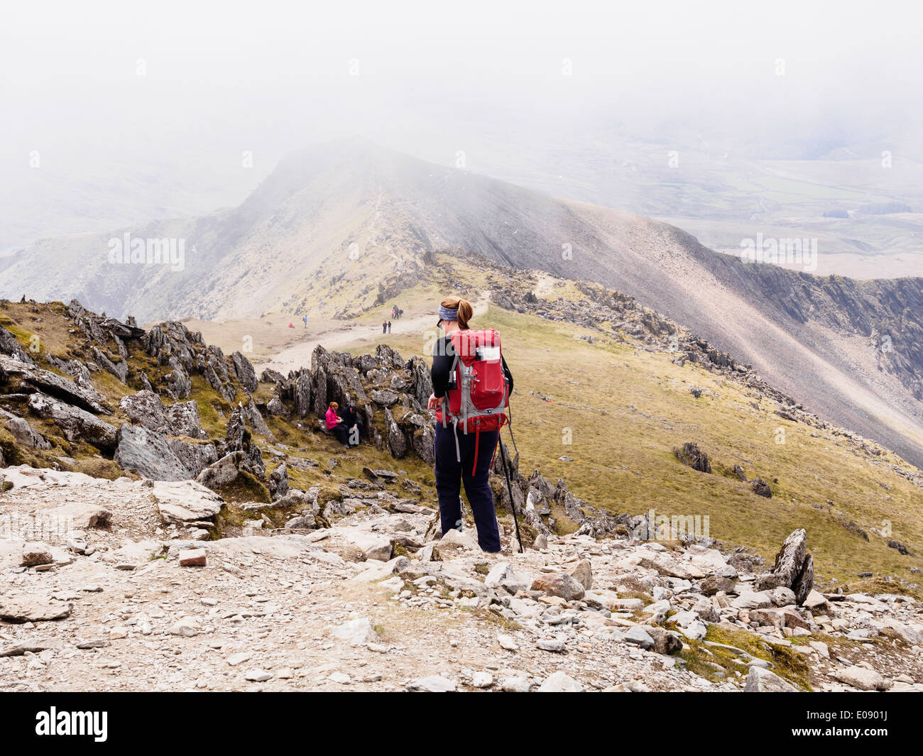 Walker walking down Rhyd Ddu path from Mt Snowdon with low cloud ...