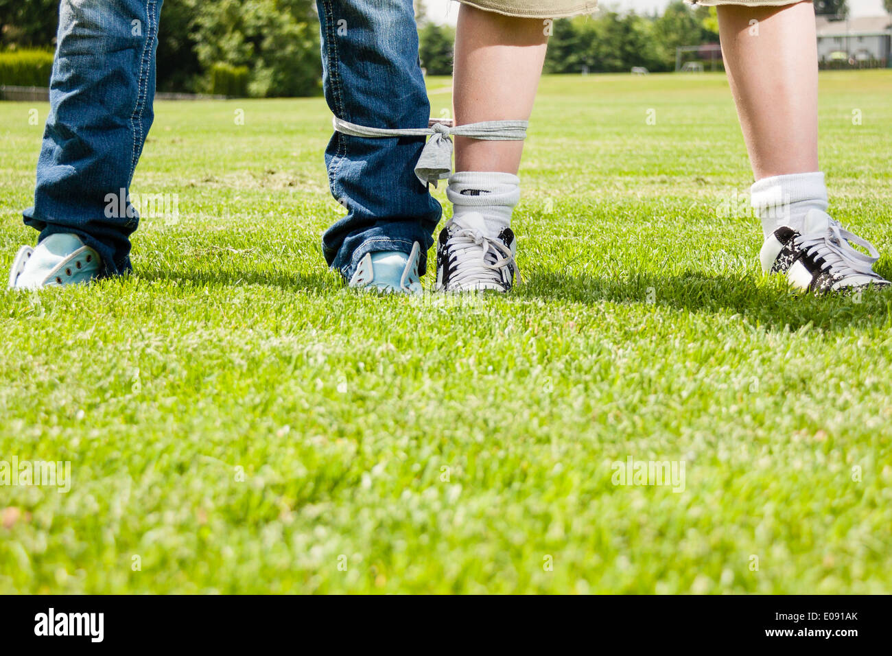 Boy and girl ready for a 3-legged race Stock Photo - Alamy