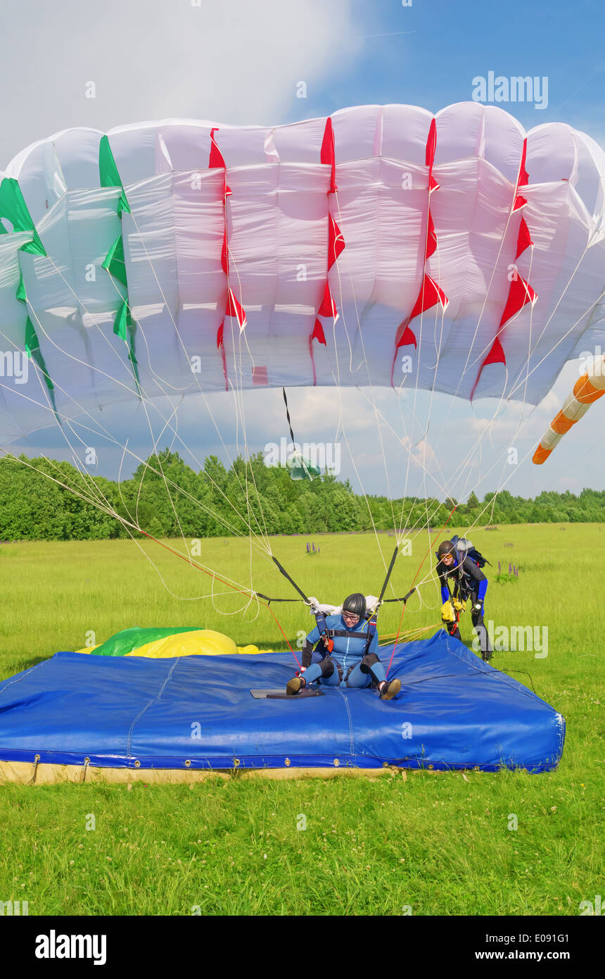 One day with parachutist in airfield. The skydiver lands under the ...