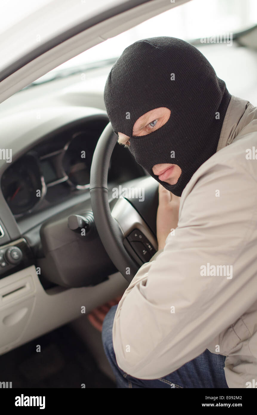 Thief in mask steals expensive new car Stock Photo - Alamy
