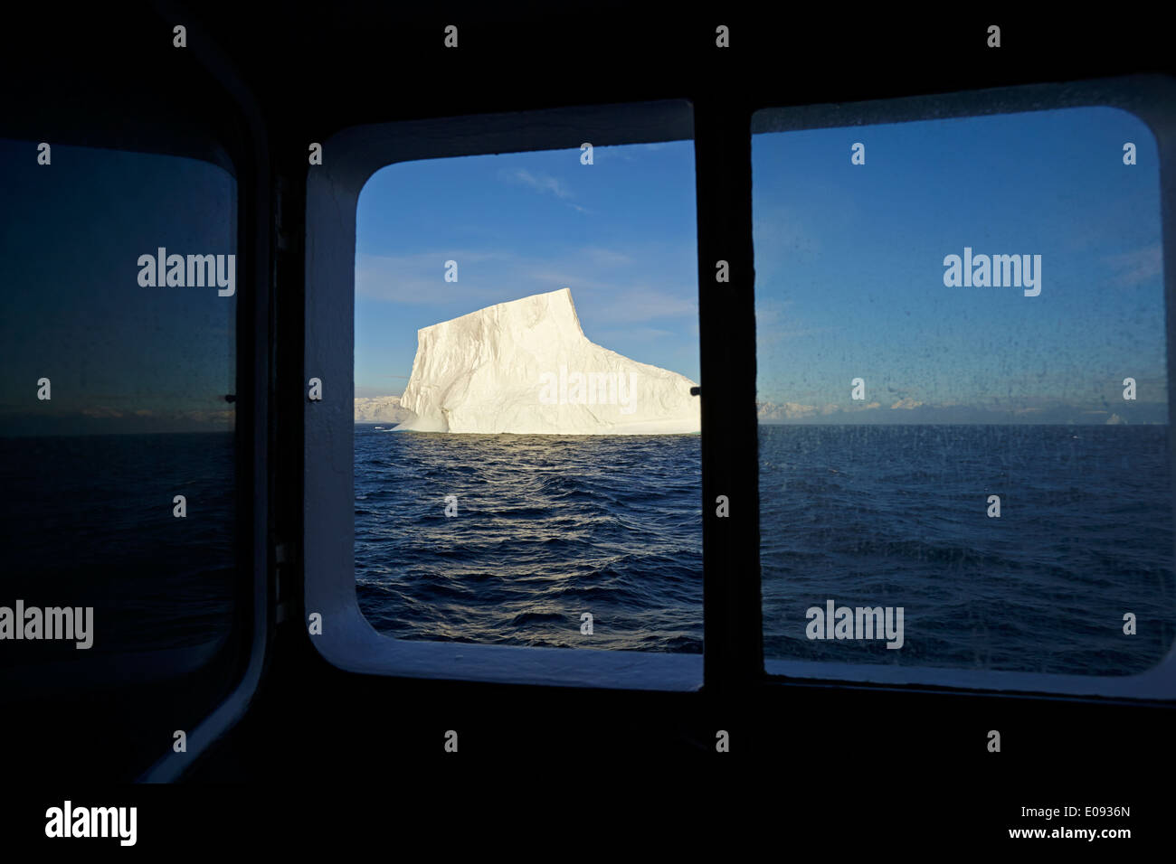large tabular iceberg viewed through ship window in the antarctic ocean ...