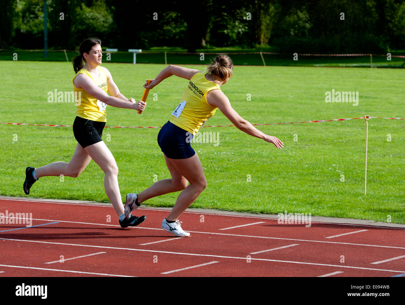 Woman runners passing baton hi-res stock photography and images - Alamy