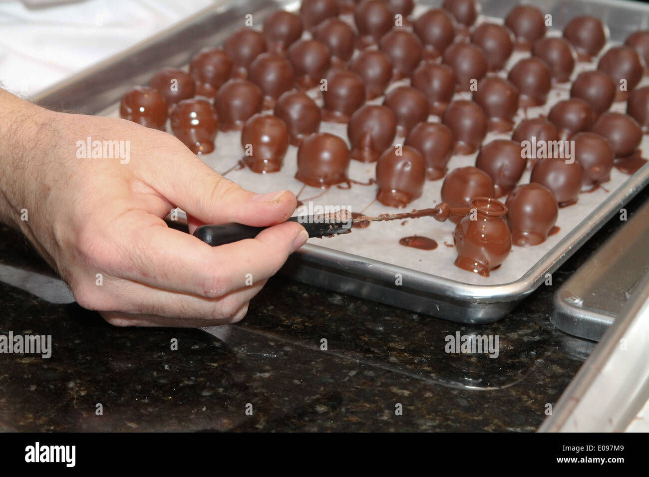 Manly Chocolates - image of a man's hand carefully placing a dipped ...