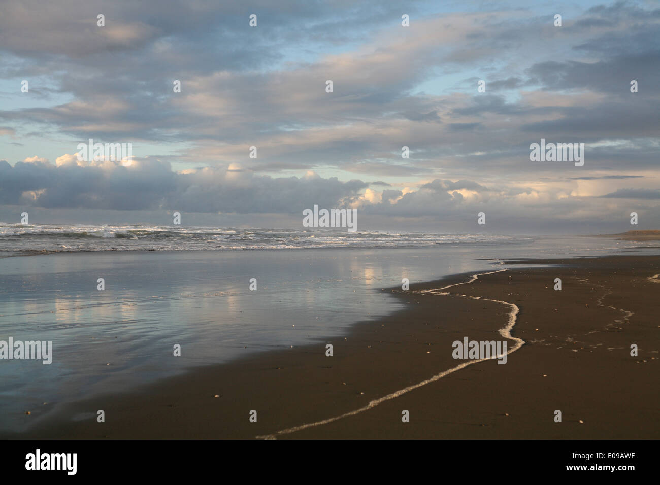 A beach after a storm with the clouds breaking Stock Photo - Alamy