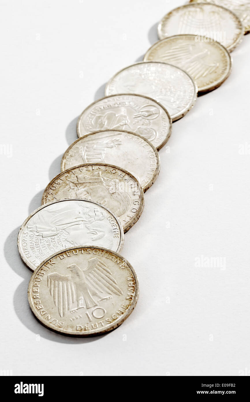 Row of nine old and new German commemorative coins on white ground ...