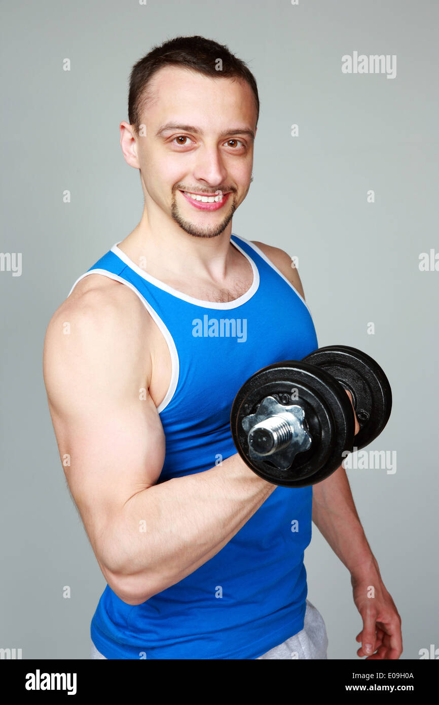 Happy man working out with dumbbells over gray background Stock Photo ...