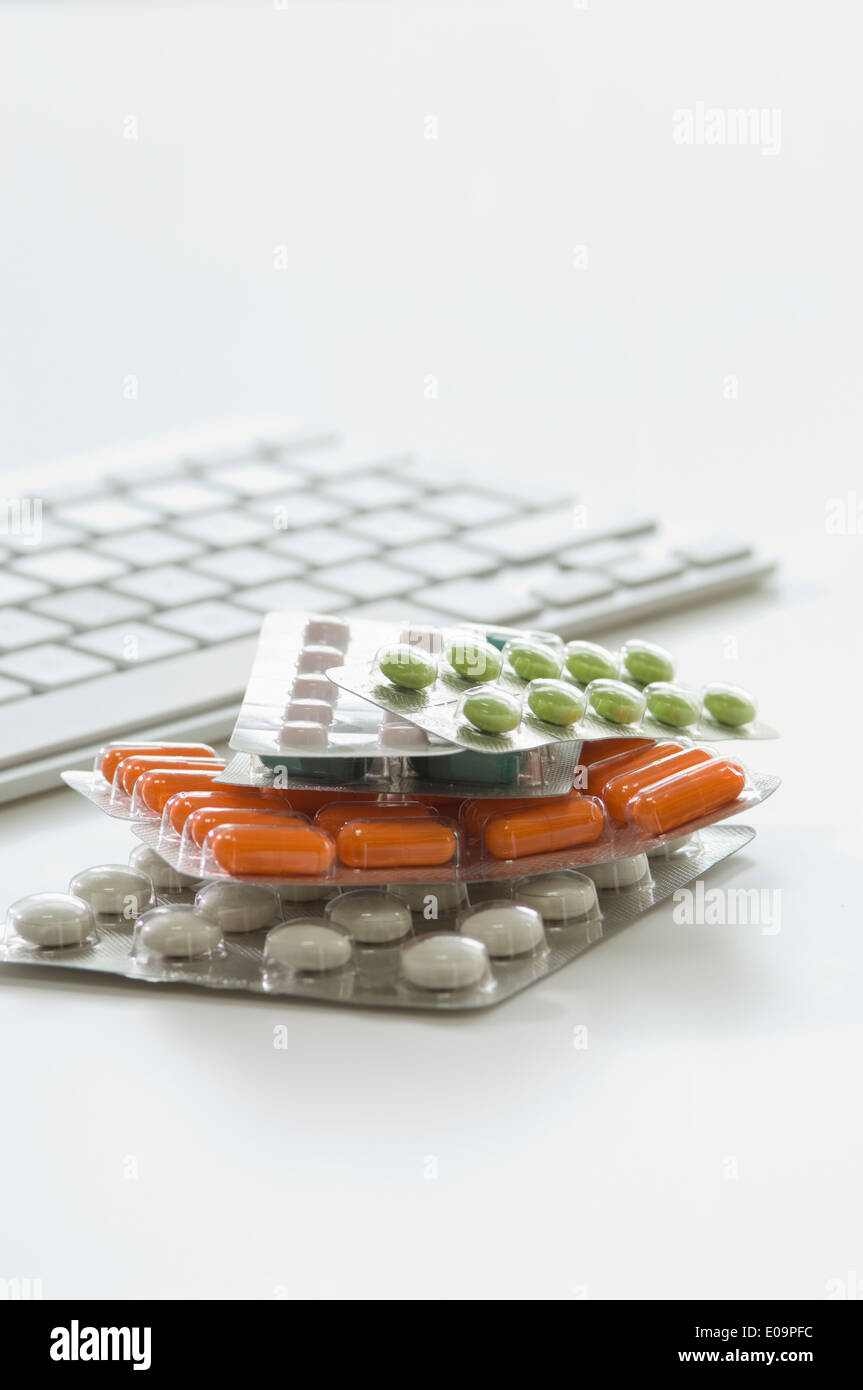 Computer keyboard with pills in blister packs Stock Photo - Alamy