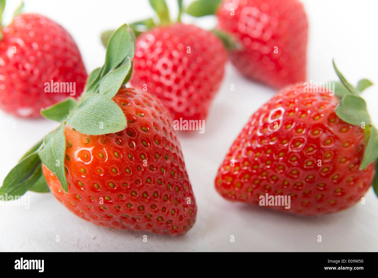 Five strawberries on white ground Stock Photo - Alamy