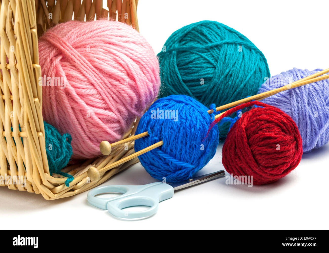 Colorful threads falling out of basket, knitting needle and scissors ...