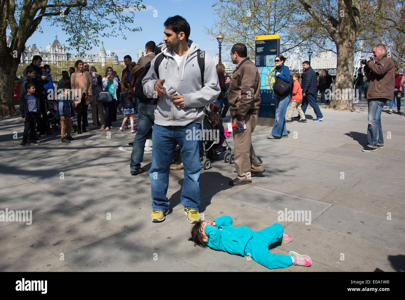 The daughter of a tourist crying on the ground seemingly looking for ...
