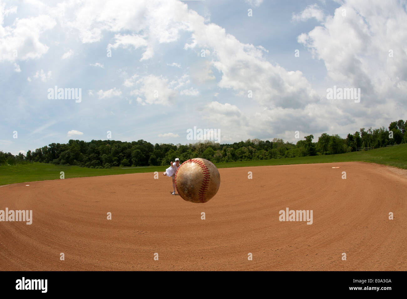 Fisheye view of a baseball apparently hovering in mid air with female ...