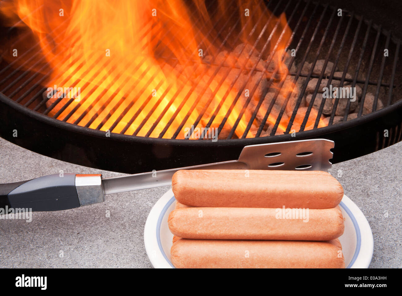Backyard barbeque lit ready to cook hot dogs Stock Photo - Alamy