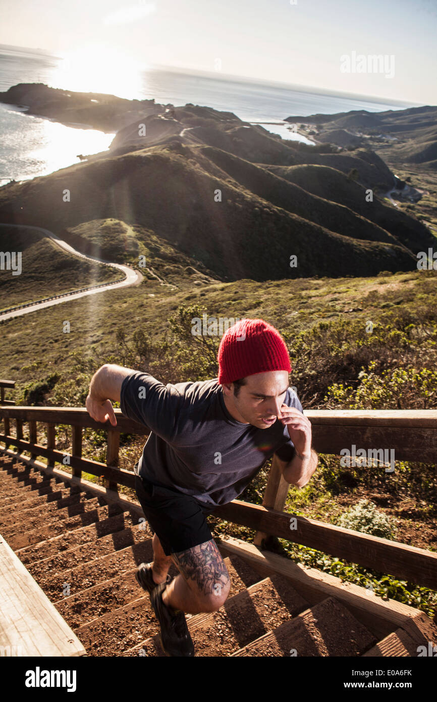 Young man running up coastal staircase Stock Photo - Alamy