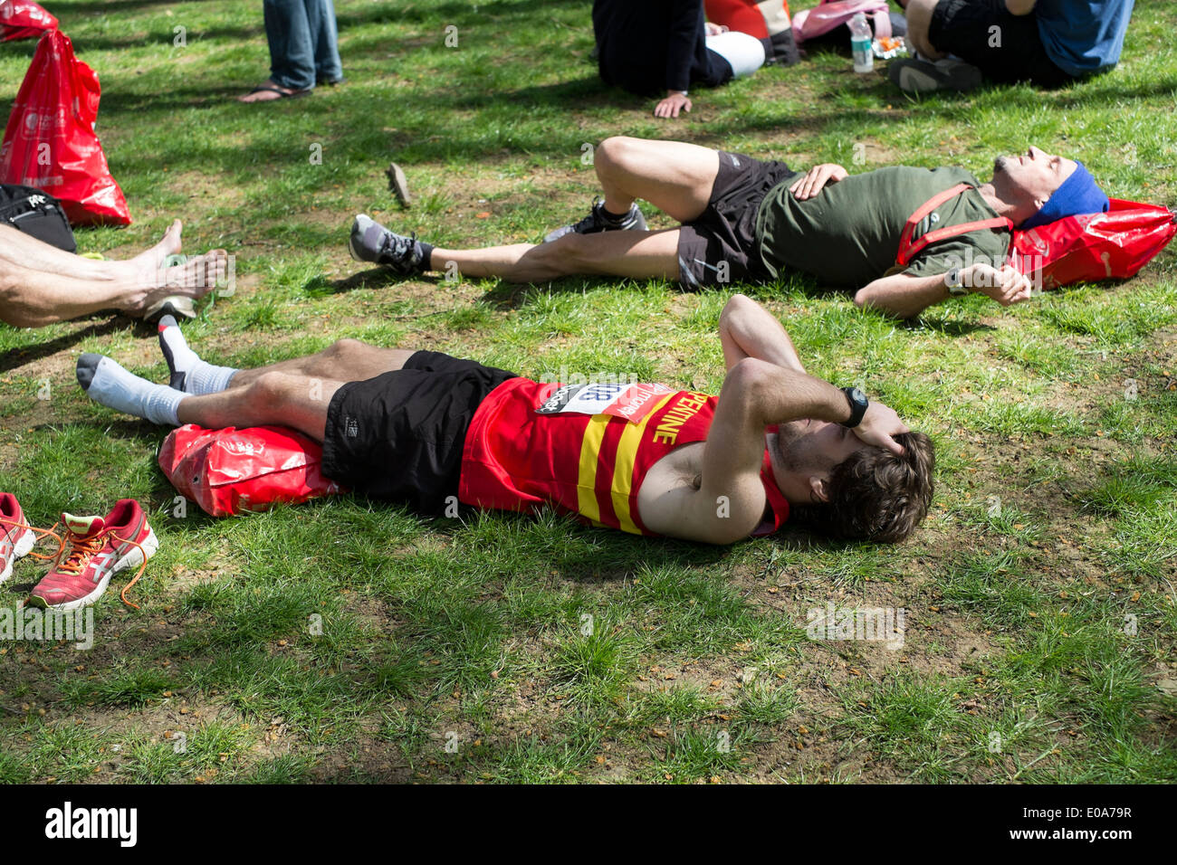 Competitors in the 2014 London Marathon. Exhausted runner at the finish ...