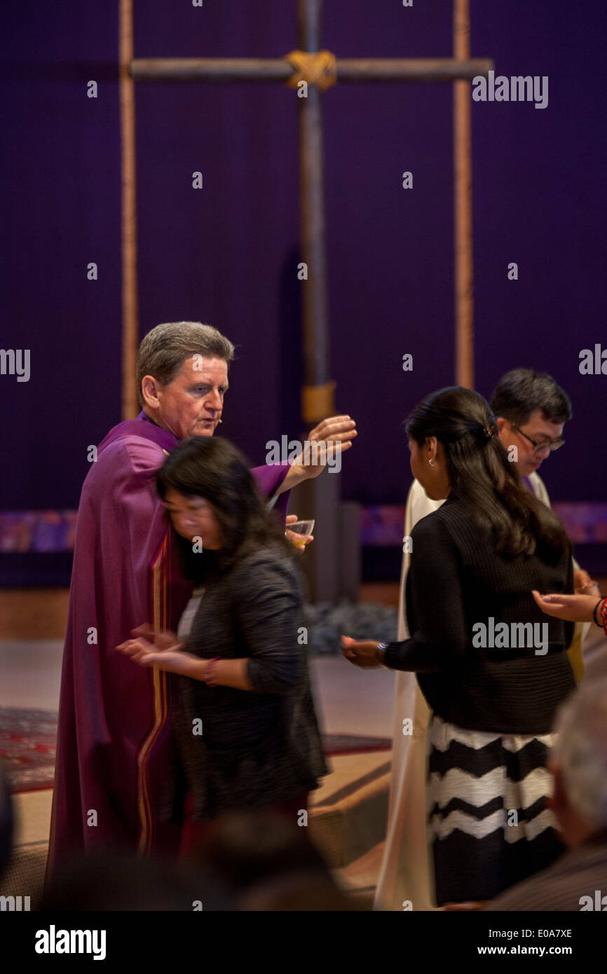 The robed priest of a Catholic church in Laguna Niguel, CA, performs ...