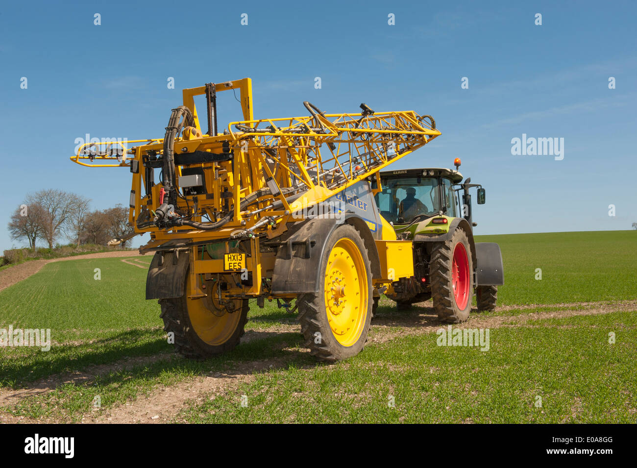 Farm crop sprayer being towed behind tractor Stock Photo - Alamy
