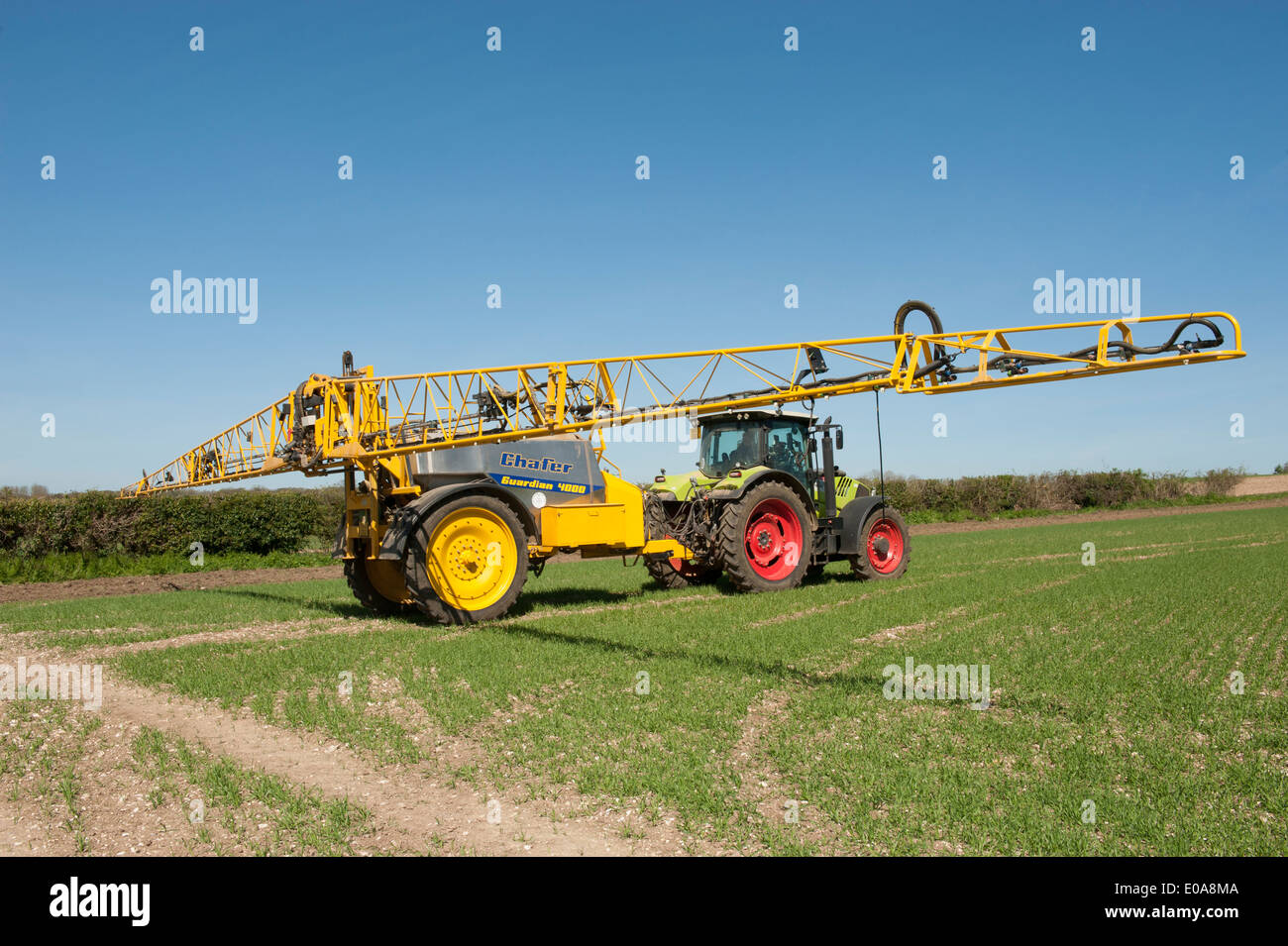 Farm crop sprayer being towed behind tractor Stock Photo - Alamy