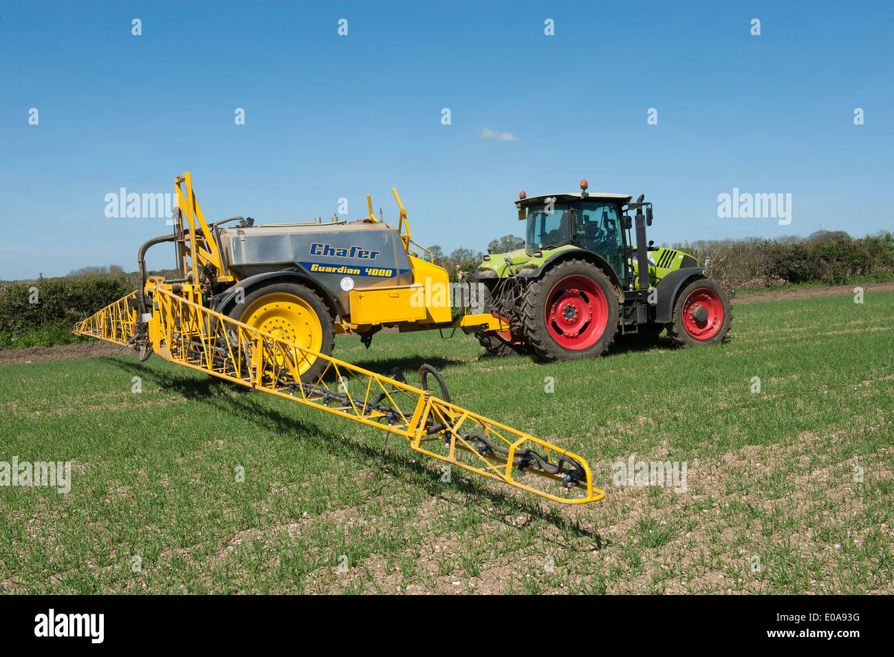 Farm crop sprayer being towed behind tractor Stock Photo - Alamy