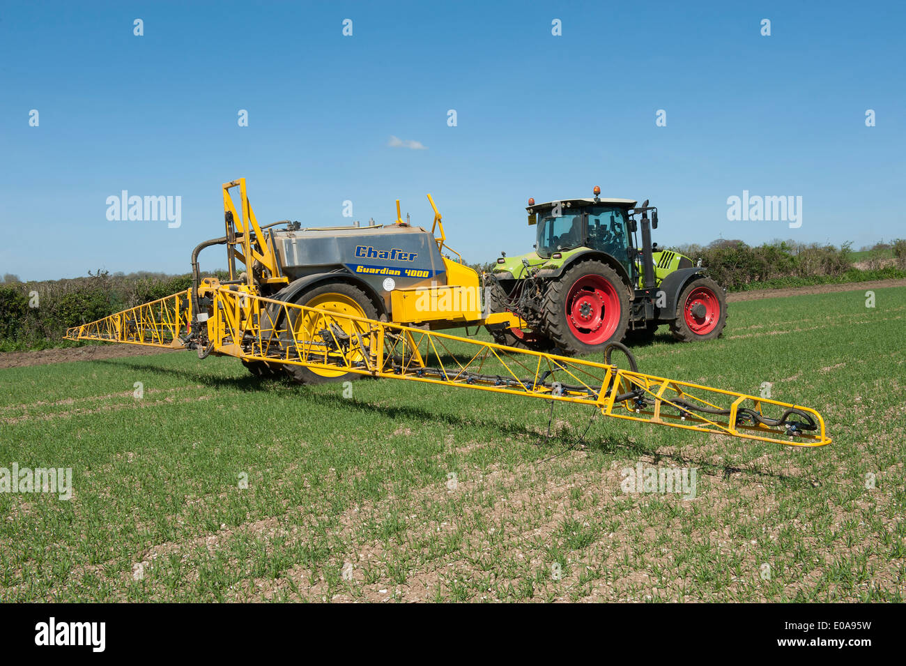 Farm crop sprayer being towed behind tractor Stock Photo - Alamy