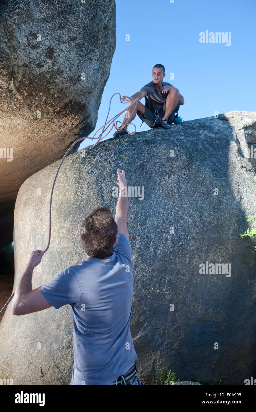 Young male climbers reaching out for each other on rock Stock Photo - Alamy