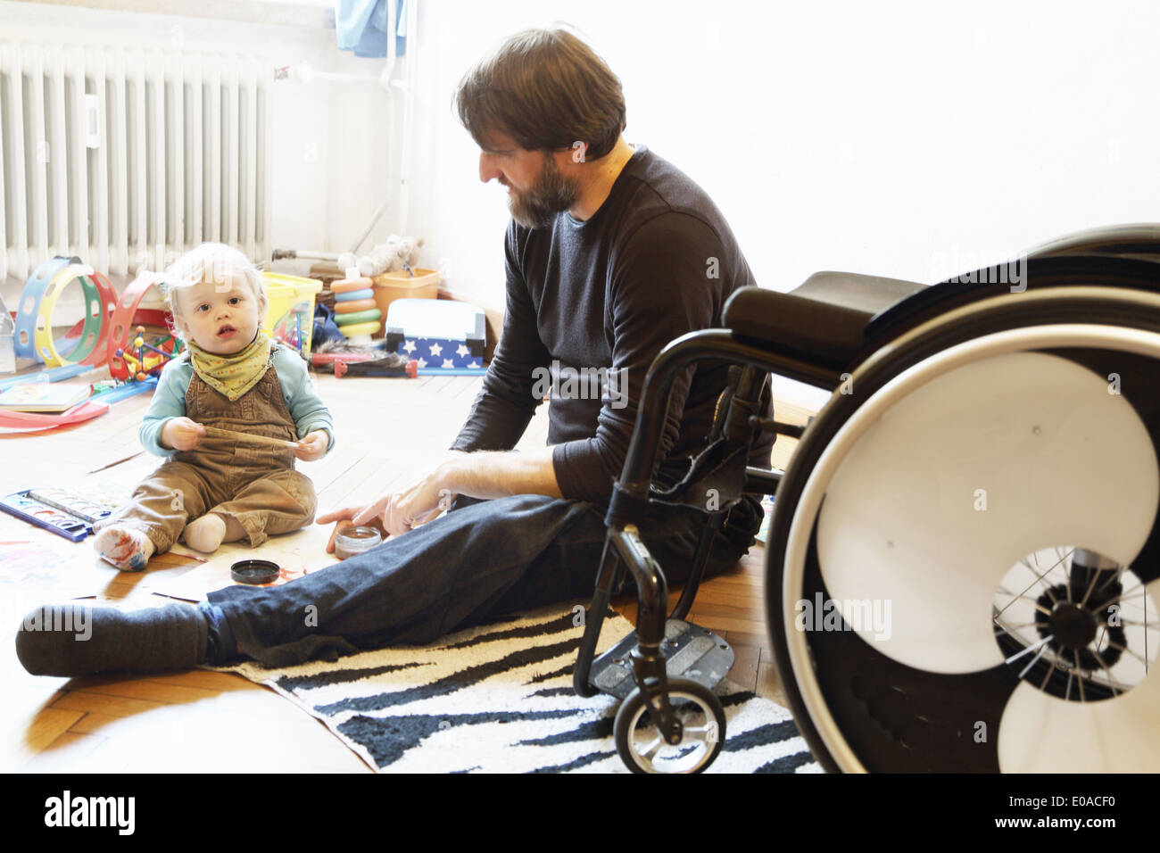 Disabled father with son playing on floor Stock Photo - Alamy