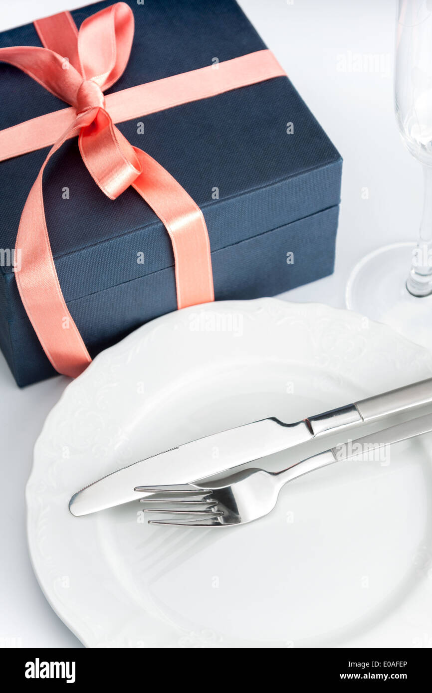 Dinner plates and cutlery with a gift Stock Photo - Alamy