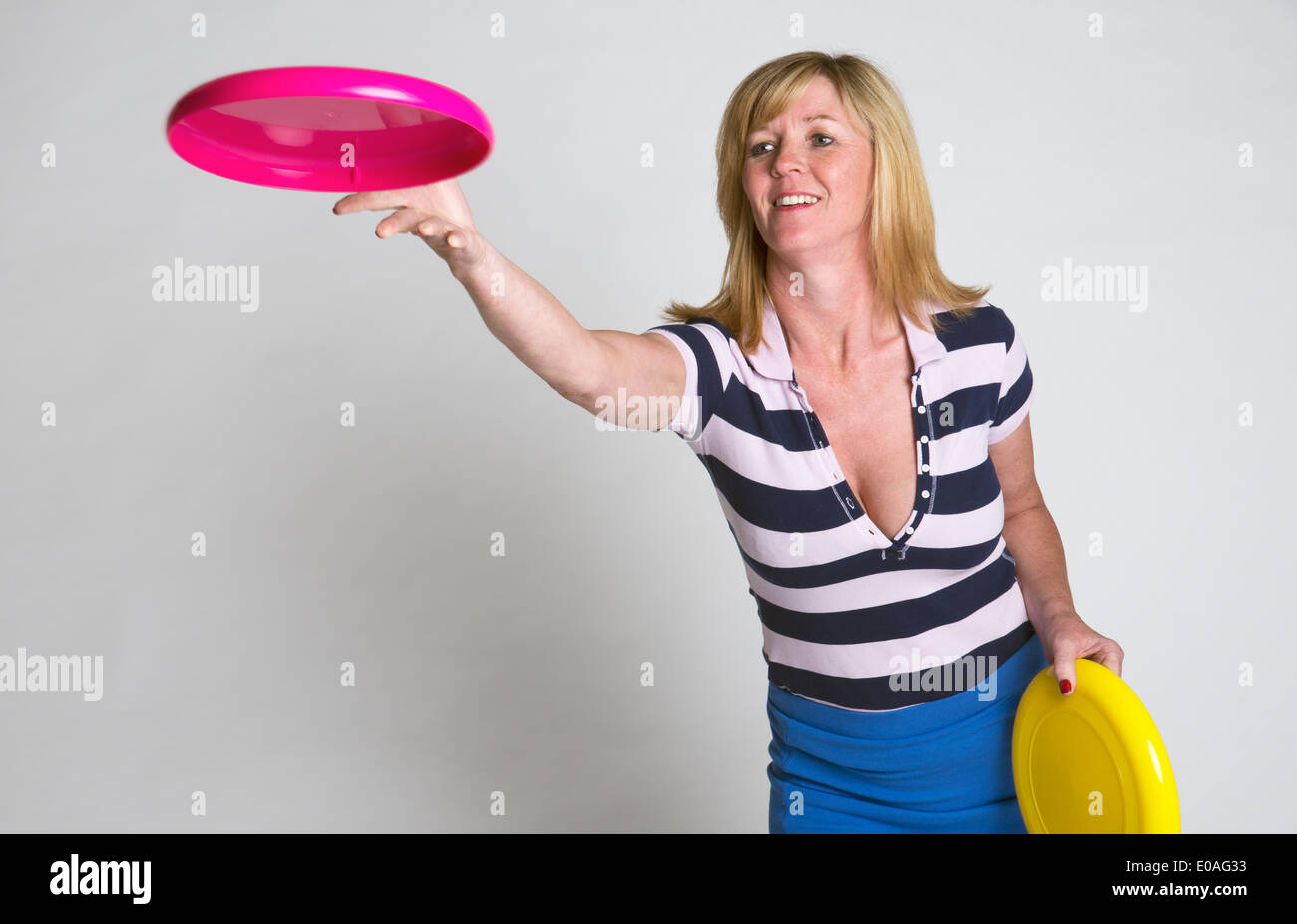 Portrait of a woman throwing a frisbee disc to keep fit Stock Photo - Alamy