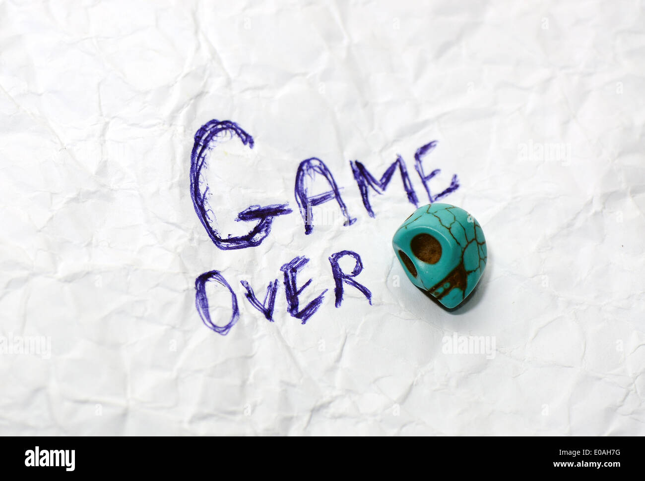 message Game Over on wrinkled paper and a skull Stock Photo - Alamy