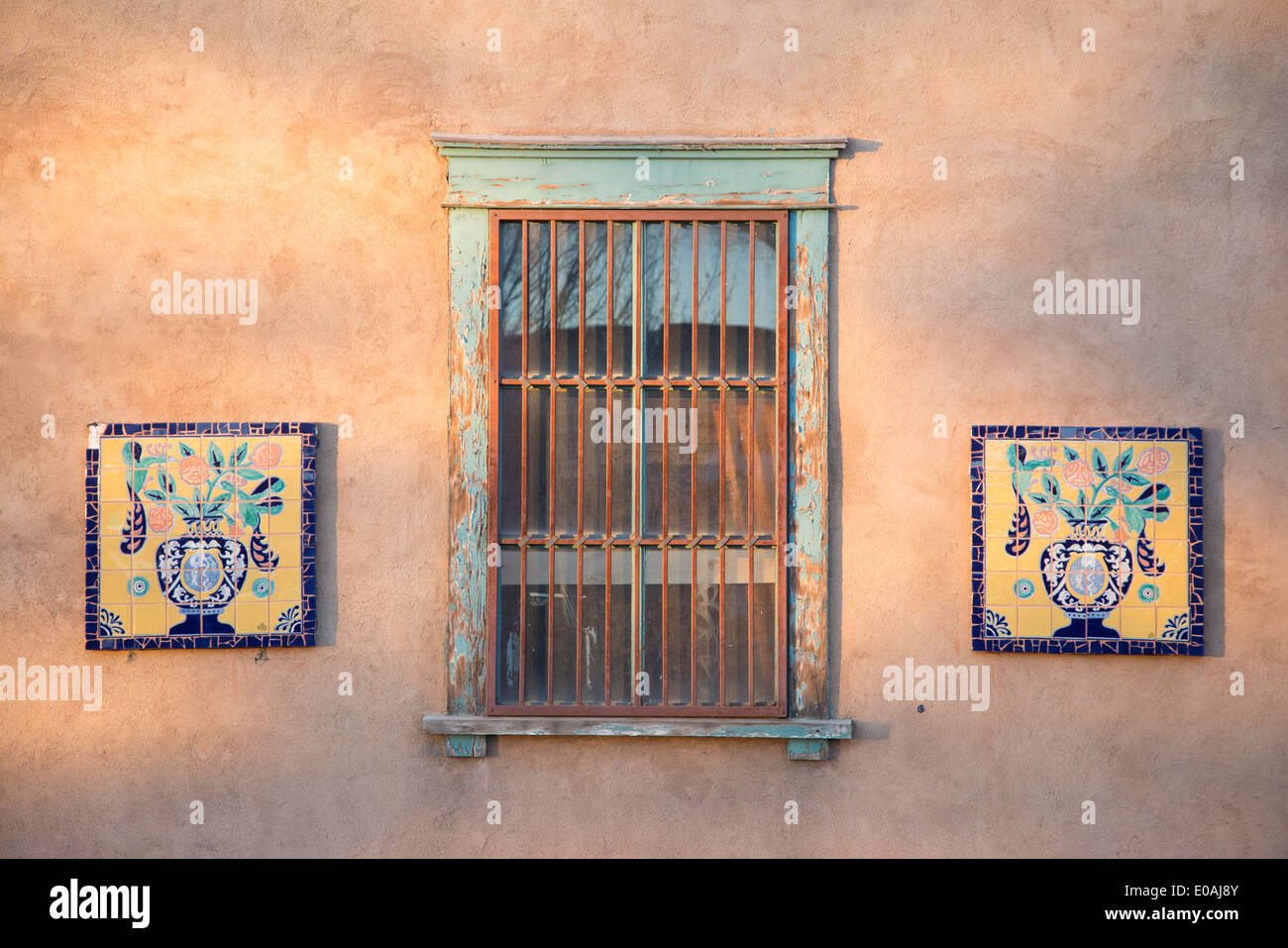 Weathered old window frame and decorative tiles on adobe building in ...