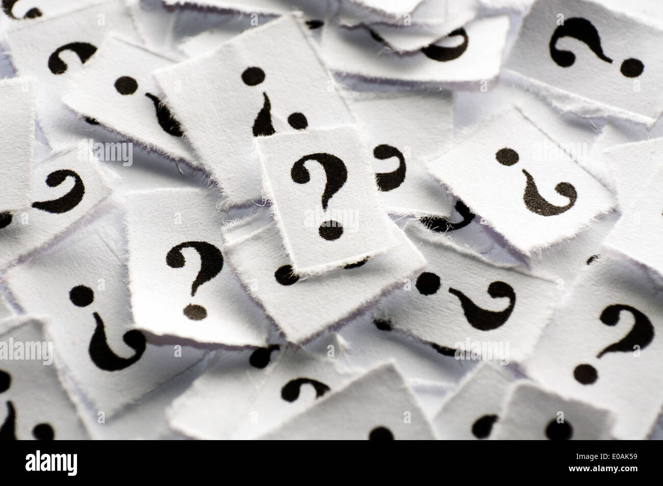 lot of question marks on white papers -hard light Stock Photo - Alamy