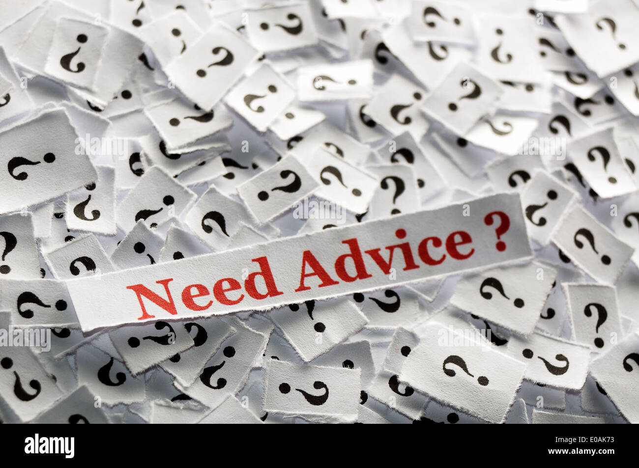 need advice question marks on white papers -hard light Stock Photo - Alamy
