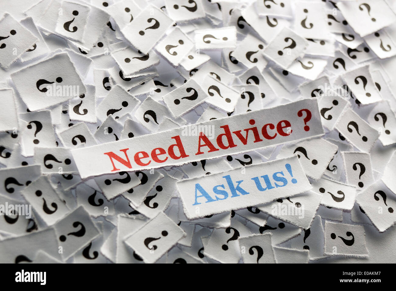 need advice question marks on white papers -hard light Stock Photo - Alamy