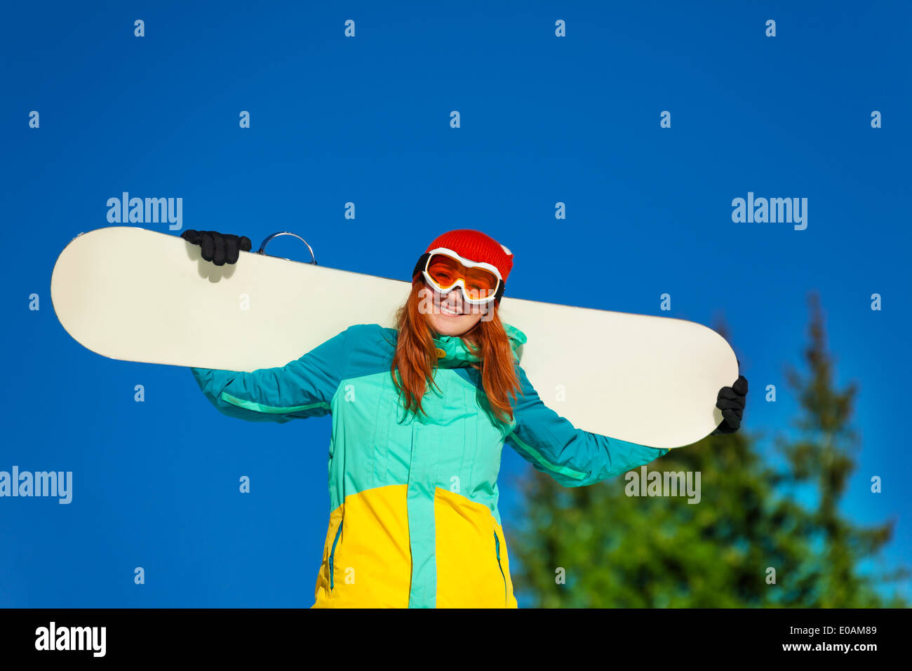 Smiling girl in ski mask holding snowboard Stock Photo - Alamy