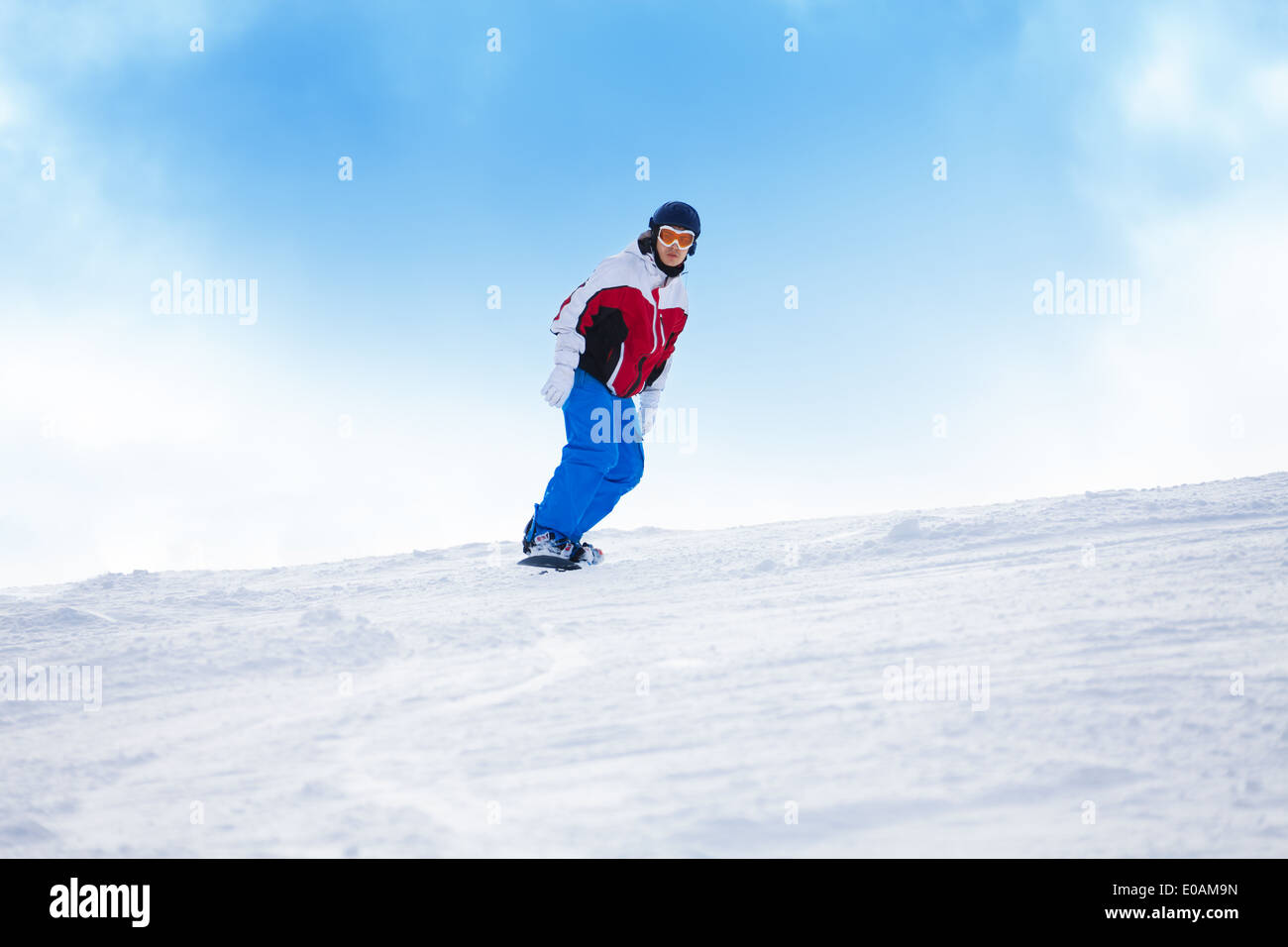 Man riding on the snowboard down mountain hill Stock Photo - Alamy