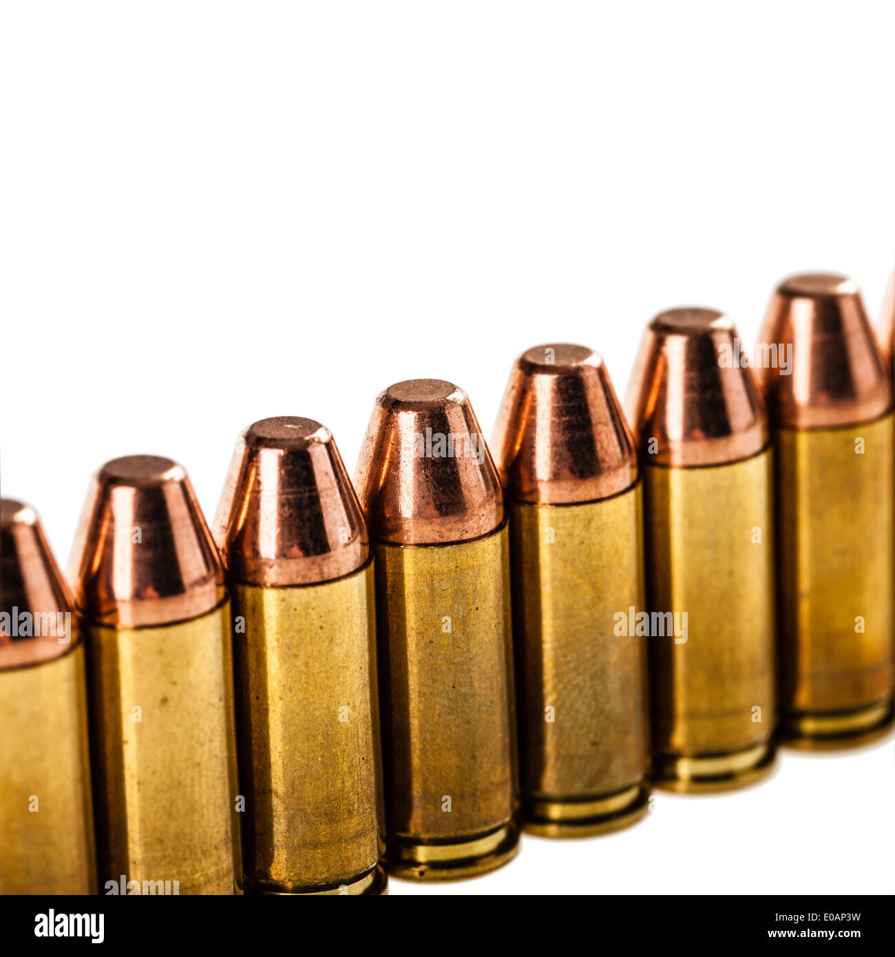 a lot of 9mm bullets arranged in a row and isolated over a white ...